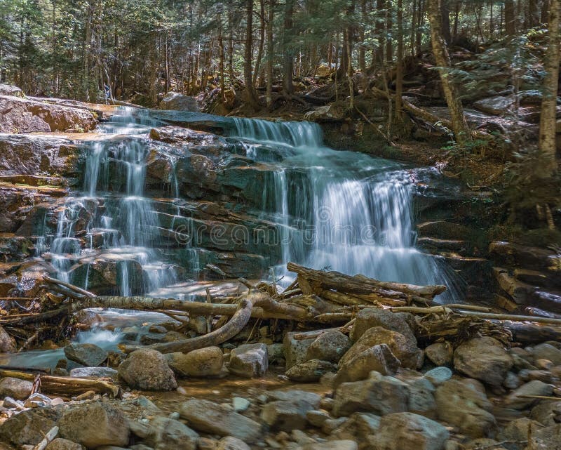 Serene Waterfall Cascading Over Rocks in a Lush Forest Setting. Stock ...