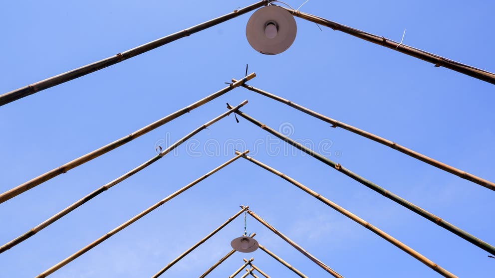 A Series of Bamboo Poles Arranged in a Triangular Pattern of Clear Blue ...