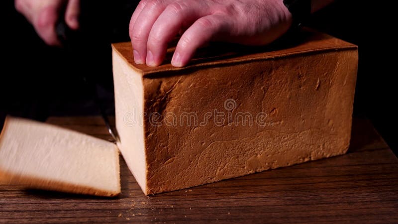 Cutting Bread on a Wooden Surface with a Knife is Comforting and ...