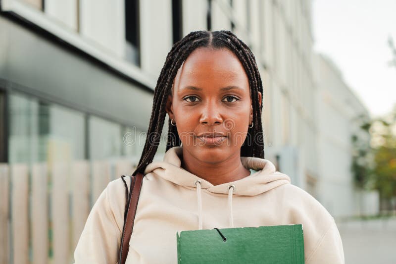 Serious African American Student Looking at Camera while Holding a ...