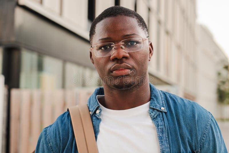 Serious African American Student Looking Pensive at the Camera, Holding ...