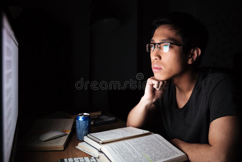 Serious Man Studying with Books and Computer in Dark Room Stock Photo ...