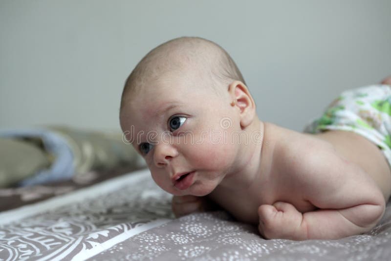 Serious baby on a bed stock image. Image of carefree - 59608595