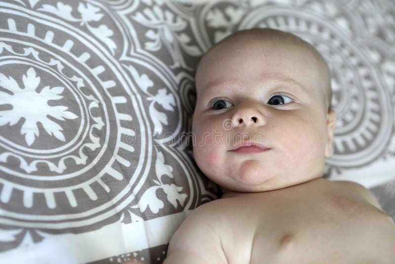 Serious baby boy on a bed stock image. Image of child - 59568111