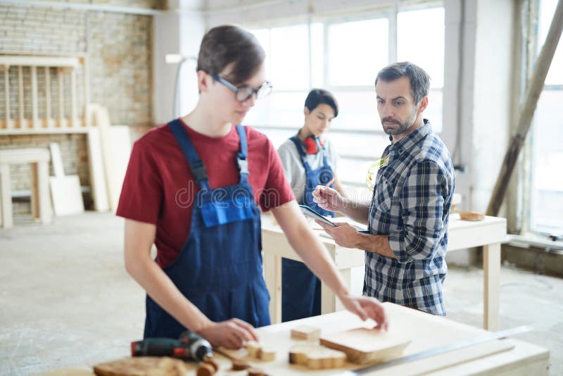 Serious Carpentry Teacher Checking Work of Students Stock Image - Image ...