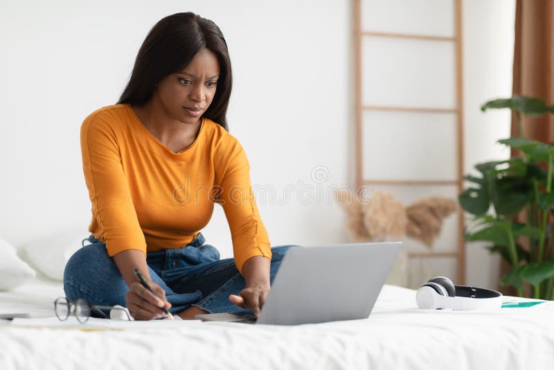 Serious Black Lady Using Laptop Browsing Internet Working in Bedroom ...