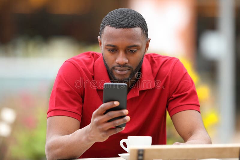Serious Black Man Using Cell Phone in a Bar Terrace Stock Image - Image ...