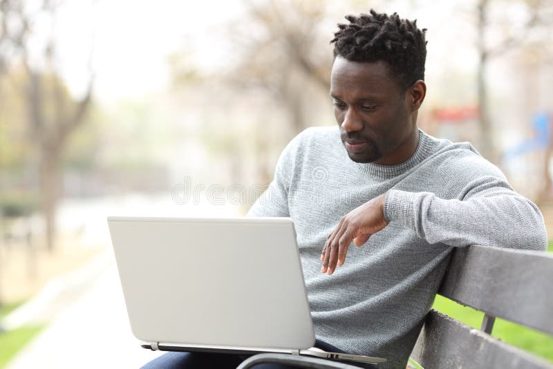 Serious Black Man Using a Laptop in a Park Stock Image - Image of ...