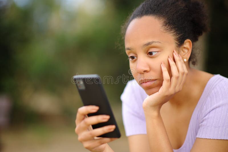 Serious Black Woman Using Cell Phone in a Park Stock Photo - Image of ...