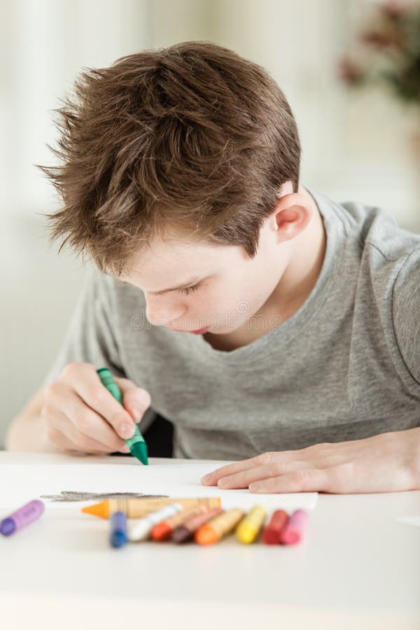 Young Boy Making Artwork Using Crayons at Table Stock Photo - Image of ...