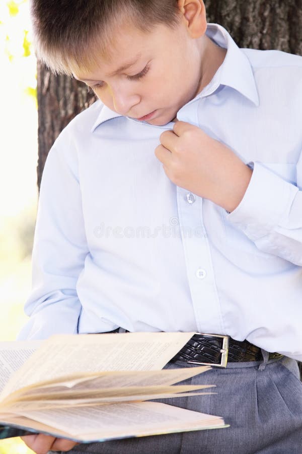 Serious boy reading book stock image. Image of cute, green - 16250681