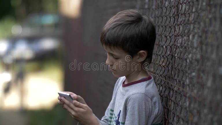 Serious Boy is Using the Phone in the Countryside Stock Image - Image ...