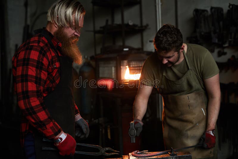 Workers hammering hot iron stock image. Image of looking - 123676251