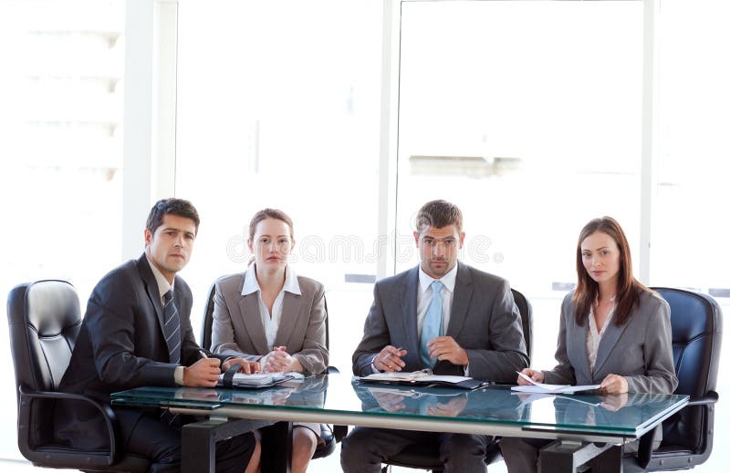 Serious Business Team Sitting Around a Table Stock Image - Image of ...