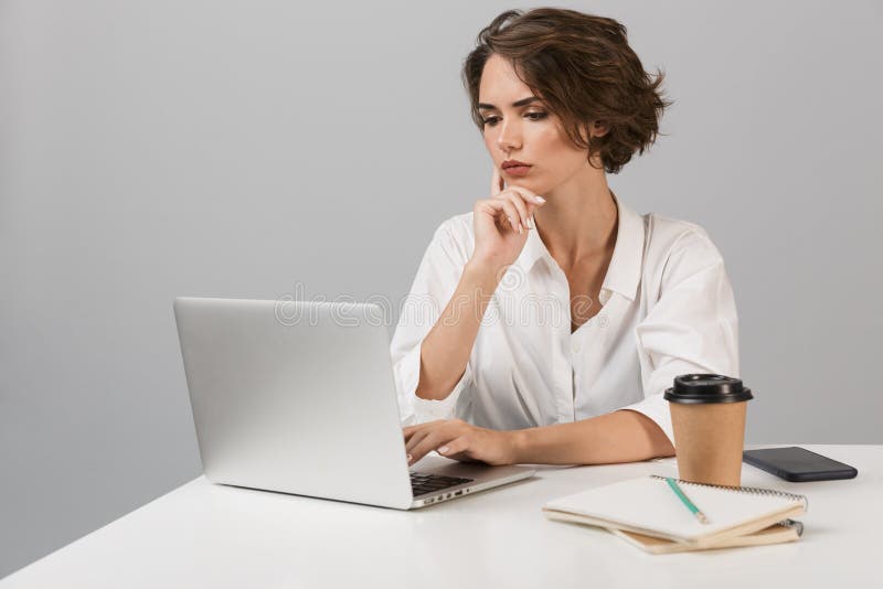 Serious Business Woman Posing Over Grey Wall Background Sitting at the ...