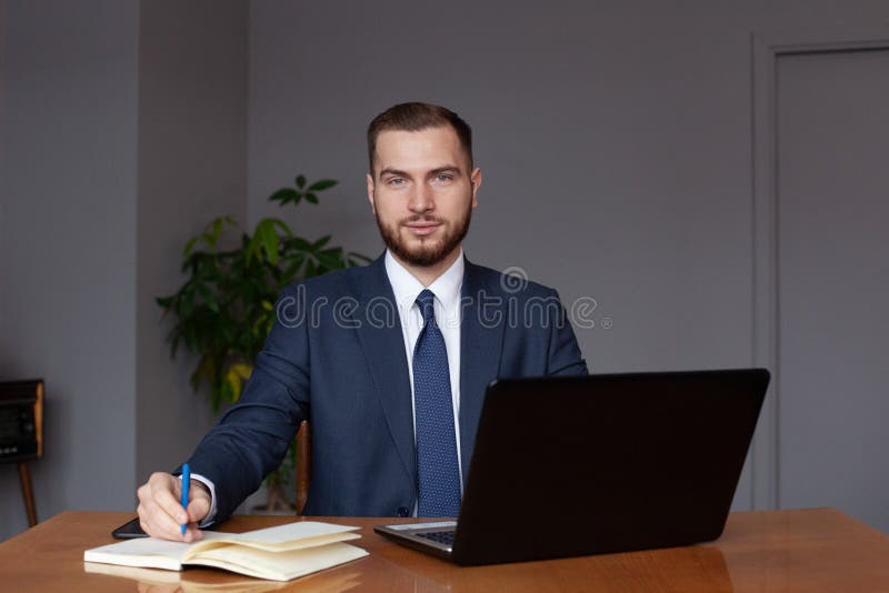 Serious Businessman in Suit is Writing Notes while Working on His ...