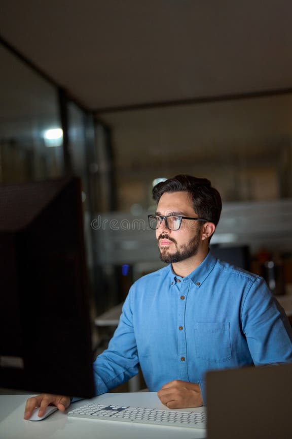 Busy Young Business Man Using Computer Working Late in Office. Vertical ...
