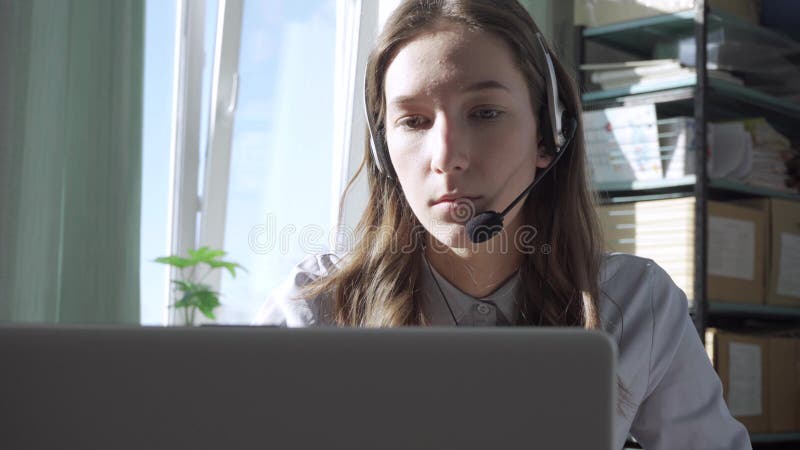 Serious Call Center Operator in Wireless Headset Talking with Customer ...