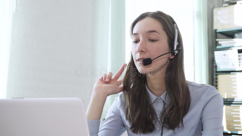 Serious Call Center Operator in Wireless Headset Talking with Customer ...