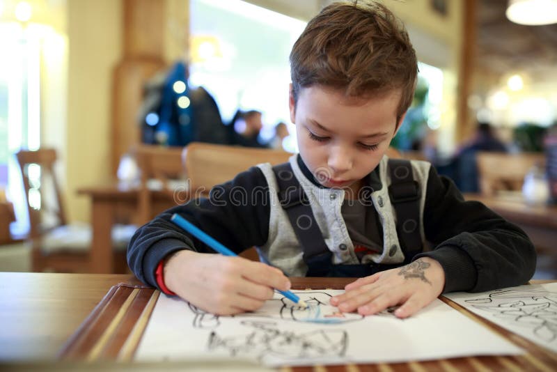 Serious Child Drawing in Restaurant Stock Image - Image of cute, cafe ...