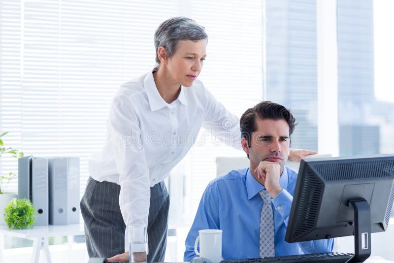 Serious Colleagues Working Together on Computer Stock Photo - Image of ...