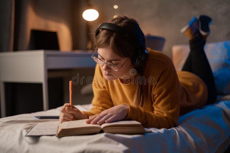 Serious College Student Reading Thick Book and Taking Notes in Textbook ...
