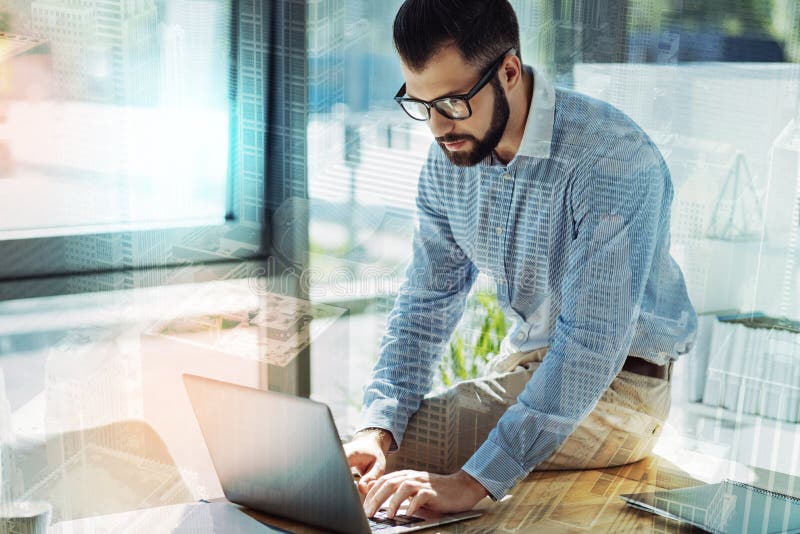 Serious Concentrated Man Sitting on the Table and Using Laptop. Stock ...