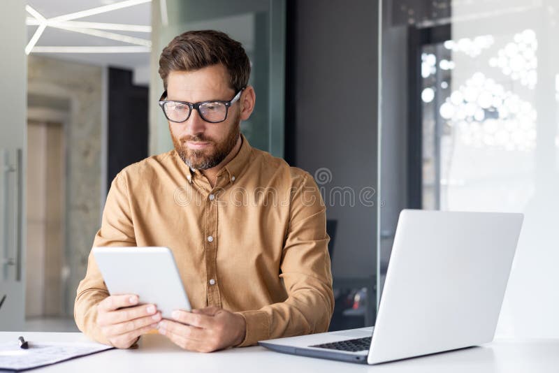 Serious Concentrated Man Working Inside Office with Tablet Computer ...