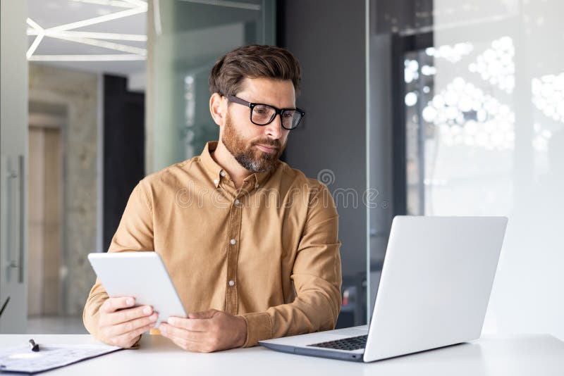Serious Concentrated Man Working Inside Office with Tablet Computer ...