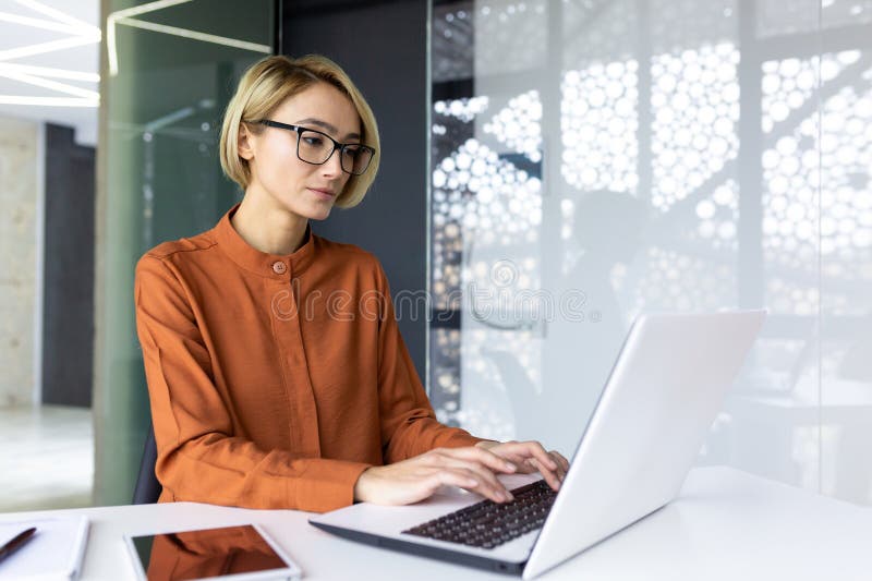 Serious Blonde Woman in Blue Shirt Standing Alone Near Glass Corporate ...