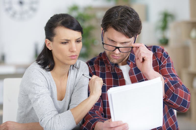 Serious Couple Reading Paperwork Together Stock Image - Image of ...