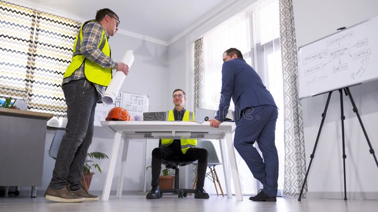 A Serious Customer is Discussing with an Engineer and a Builder the ...