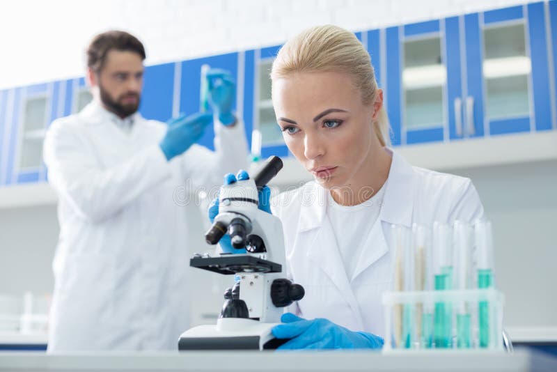 Serious Female Biologist Looking into the Microscope Stock Image ...