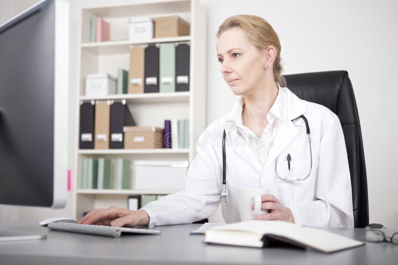 Serious Female Doctor Using Her Desktop Computer Stock Photo - Image of ...