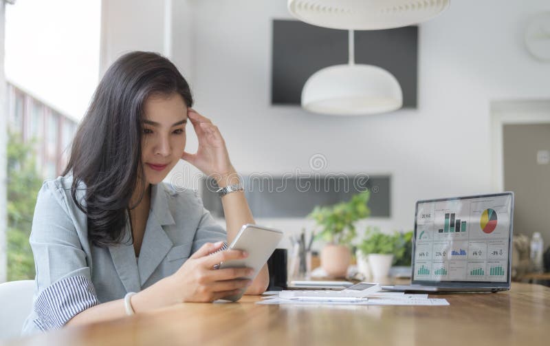 Serious Female Employee Using Mobile Phone at Office Desk Stock Image ...