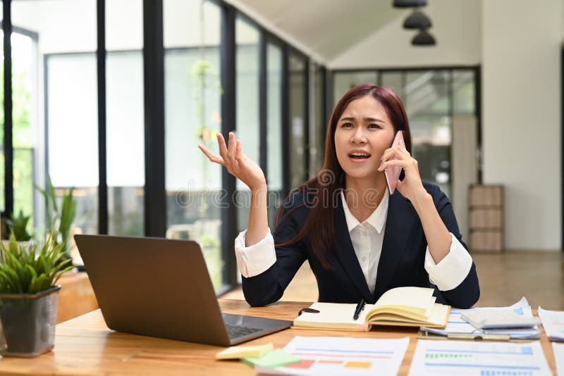 Serious Female Entrepreneur Having Serious Conversation on Mobile Phone ...
