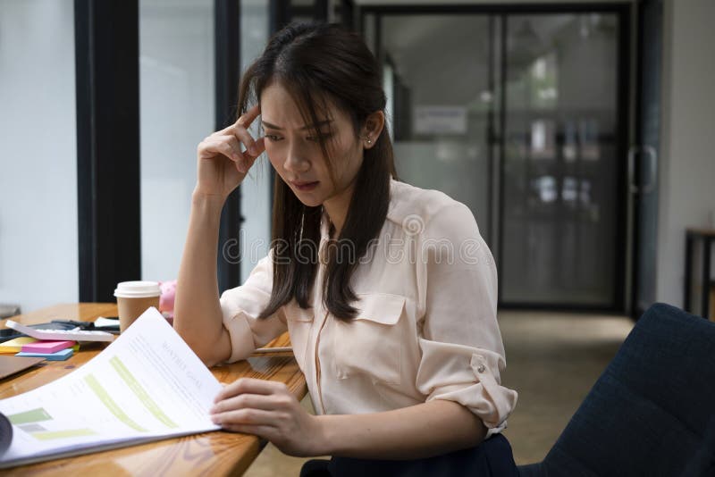 Serious Female Office Worker Analyzing Paper Work at Office. Stock ...