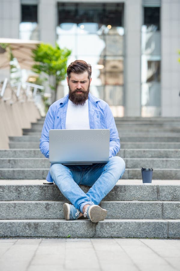 Serious Freelancer Typing on Laptop Sitting on Stairs. Freelancer Man ...