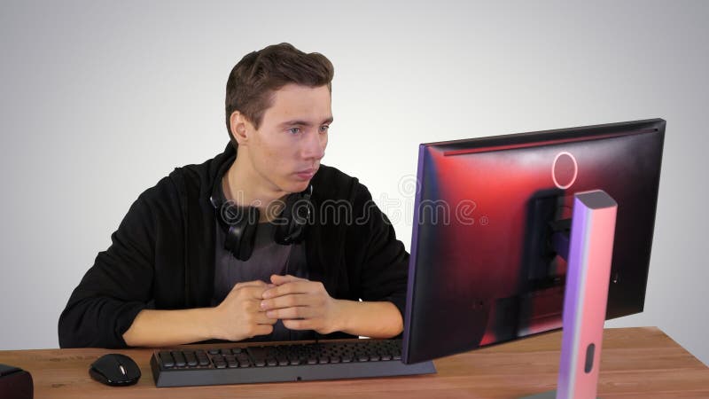 Serious Gamer Sitting at Computer Watching a Game on Gradient Ba Stock ...