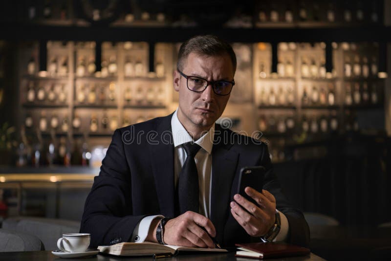 Serious Handsome Elegant Businessman Sitting at Restaurant Using His ...