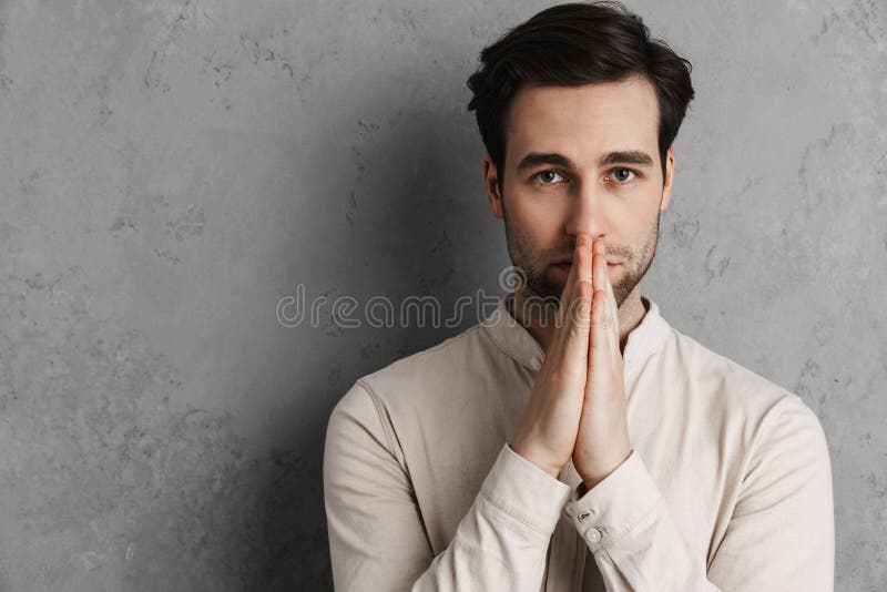 Serious Handsome Guy Looking at Camera while Posing with Palms Together ...