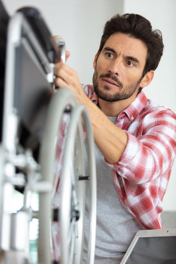 Serious Handyman Maintening Wheelchair in Workshop Stock Image - Image ...