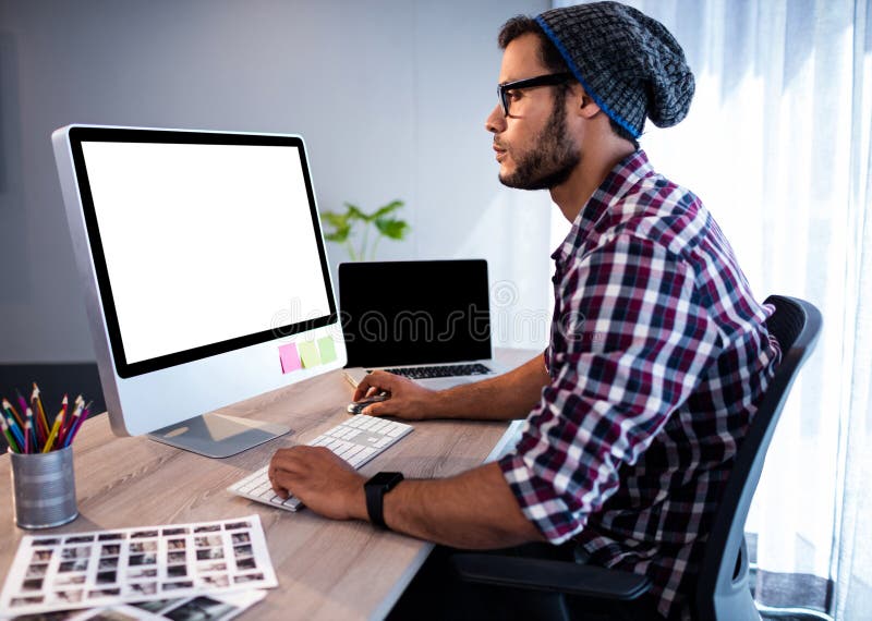 Serious Hipster Working at Computer Desk Stock Photo - Image of ...