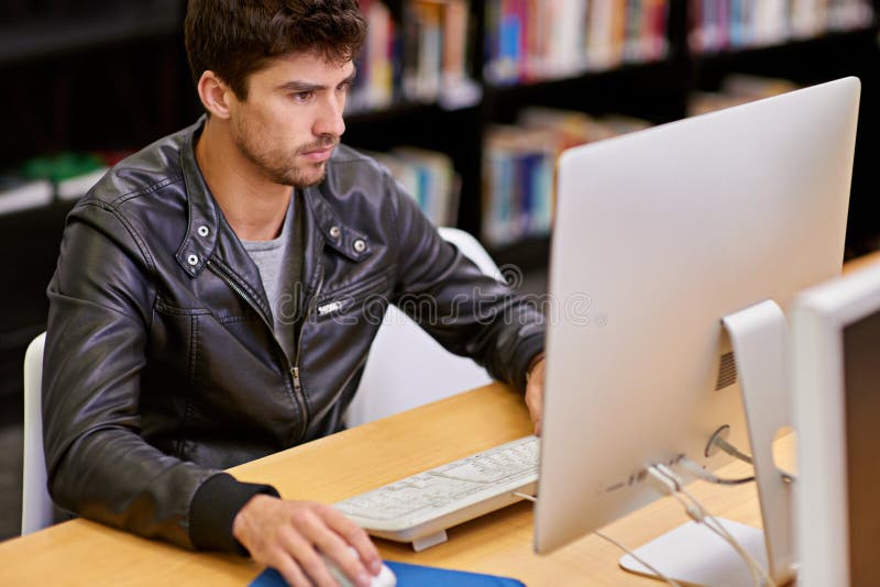 Serious about His Studies. a Male Student Working on a Computer in a ...