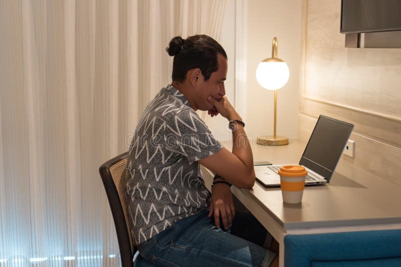 Serious Hispanic Man Working on an Online Laptop, Sitting at the ...