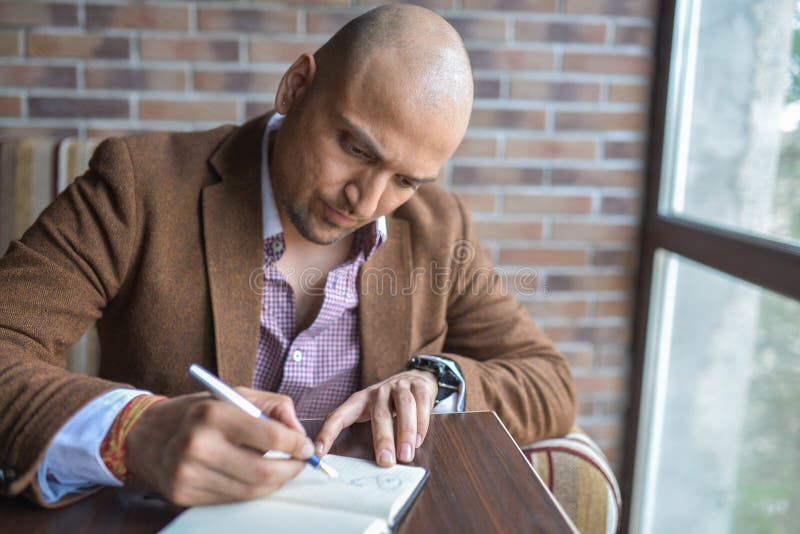 Serious Indian Man Making Some Notes in His Notebook, Business Plan or ...