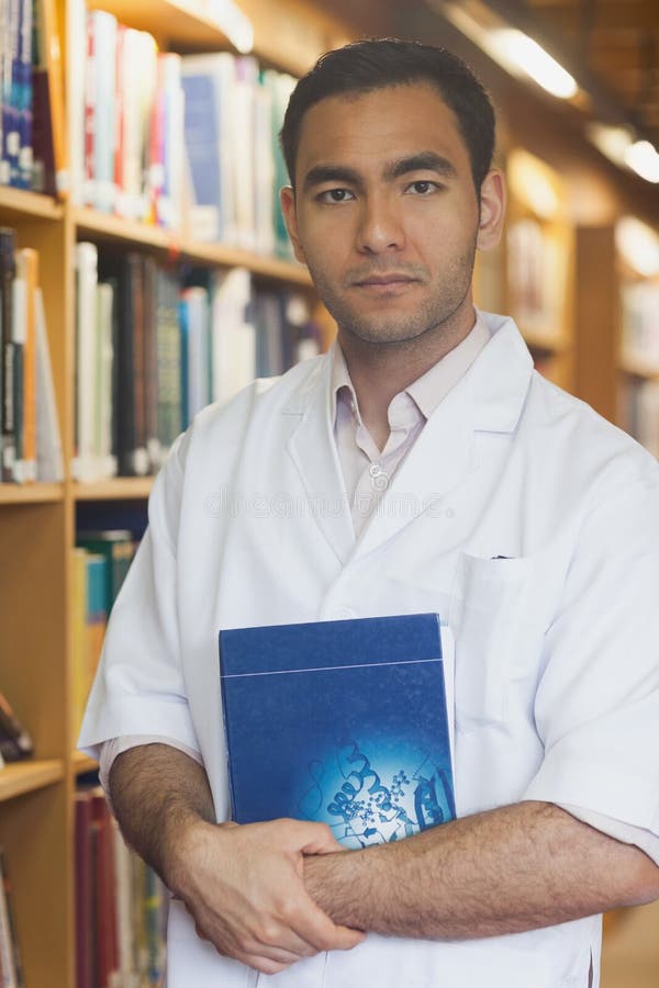 Serious Intellectual Man Posing in Library with a Book Stock Photo ...