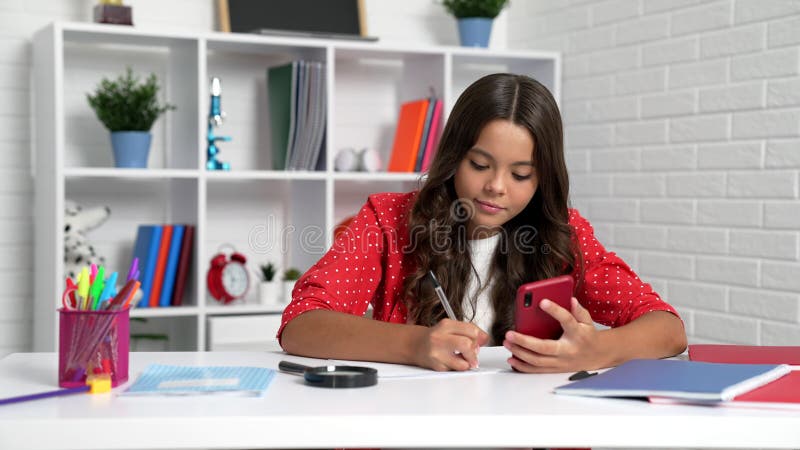 Serious Kid Doing Classwork Using Mobile Phone in Classroom, Smartphone ...