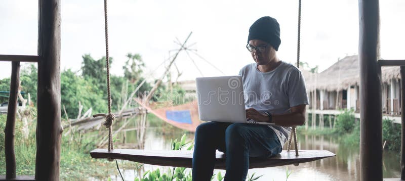 A Serious Looking Asian Man is Working Hard Using His Laptop Computer ...