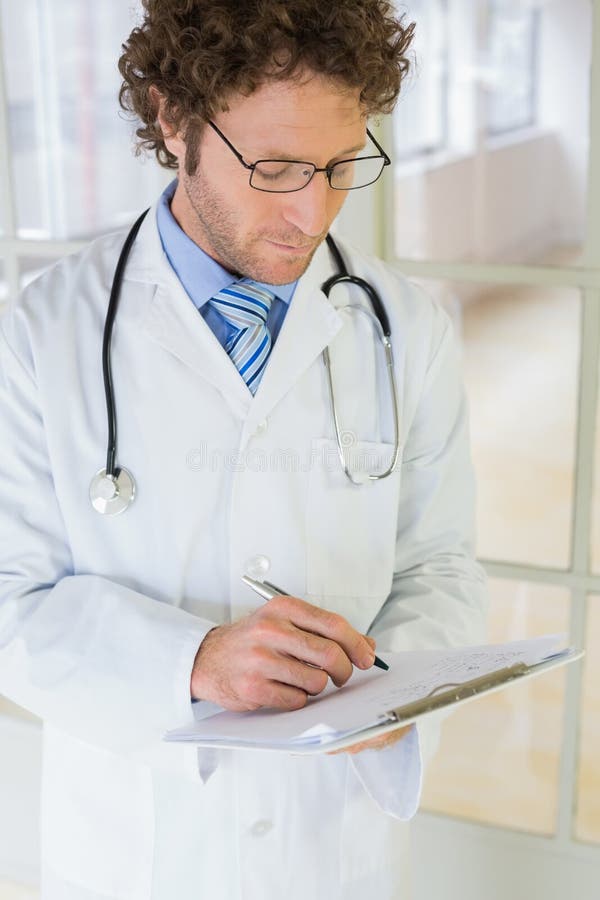 Serious Male Doctor Writing Reports in Hospital Stock Image - Image of ...